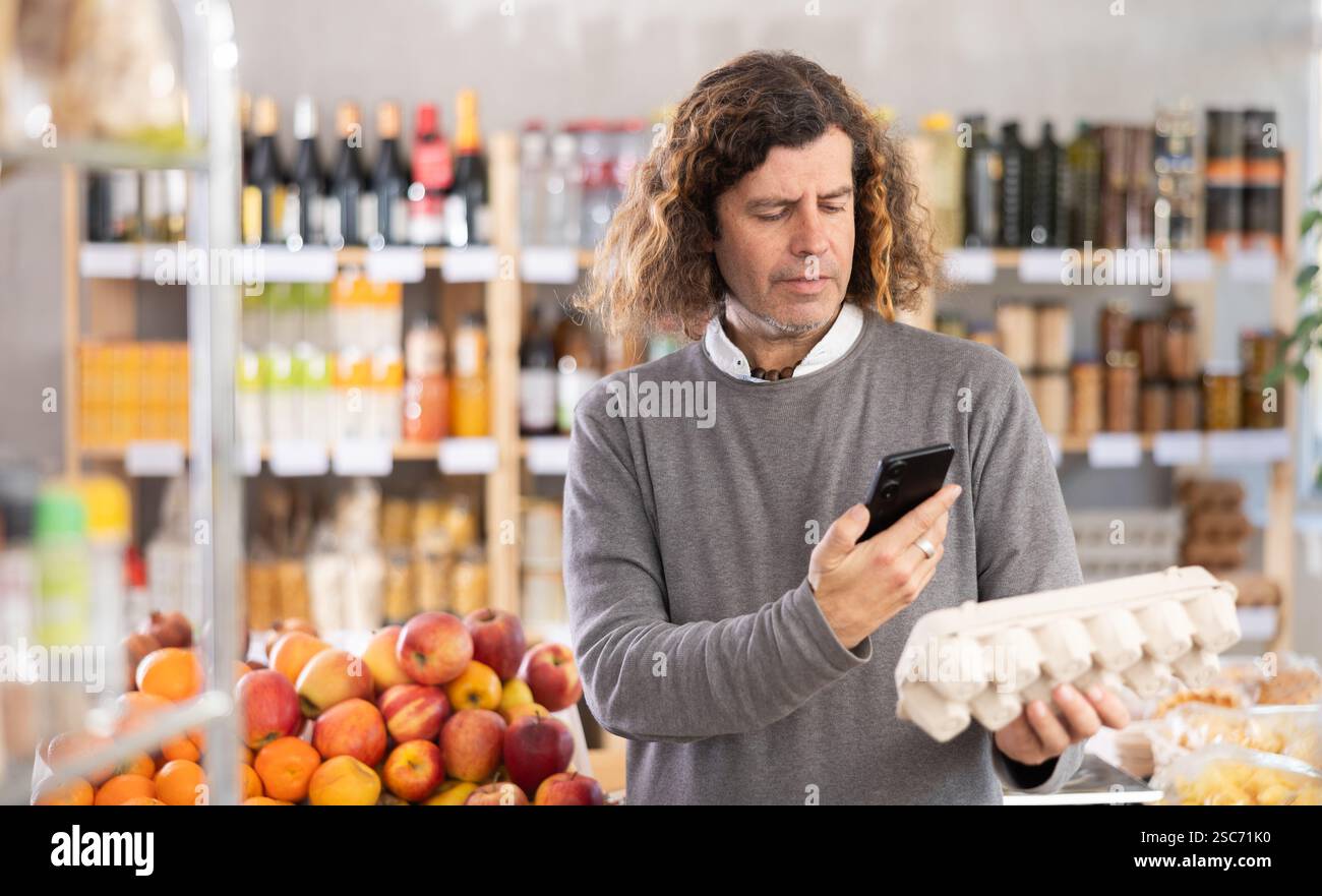 Adult man scanning qr code of eggs Stock Photo - Alamy