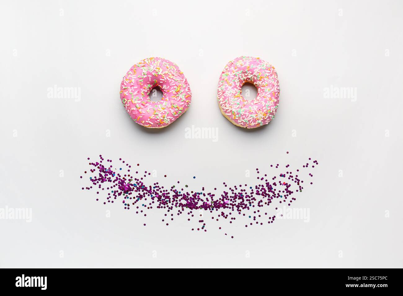 Smile made of donuts with confetti on white background Stock Photo - Alamy