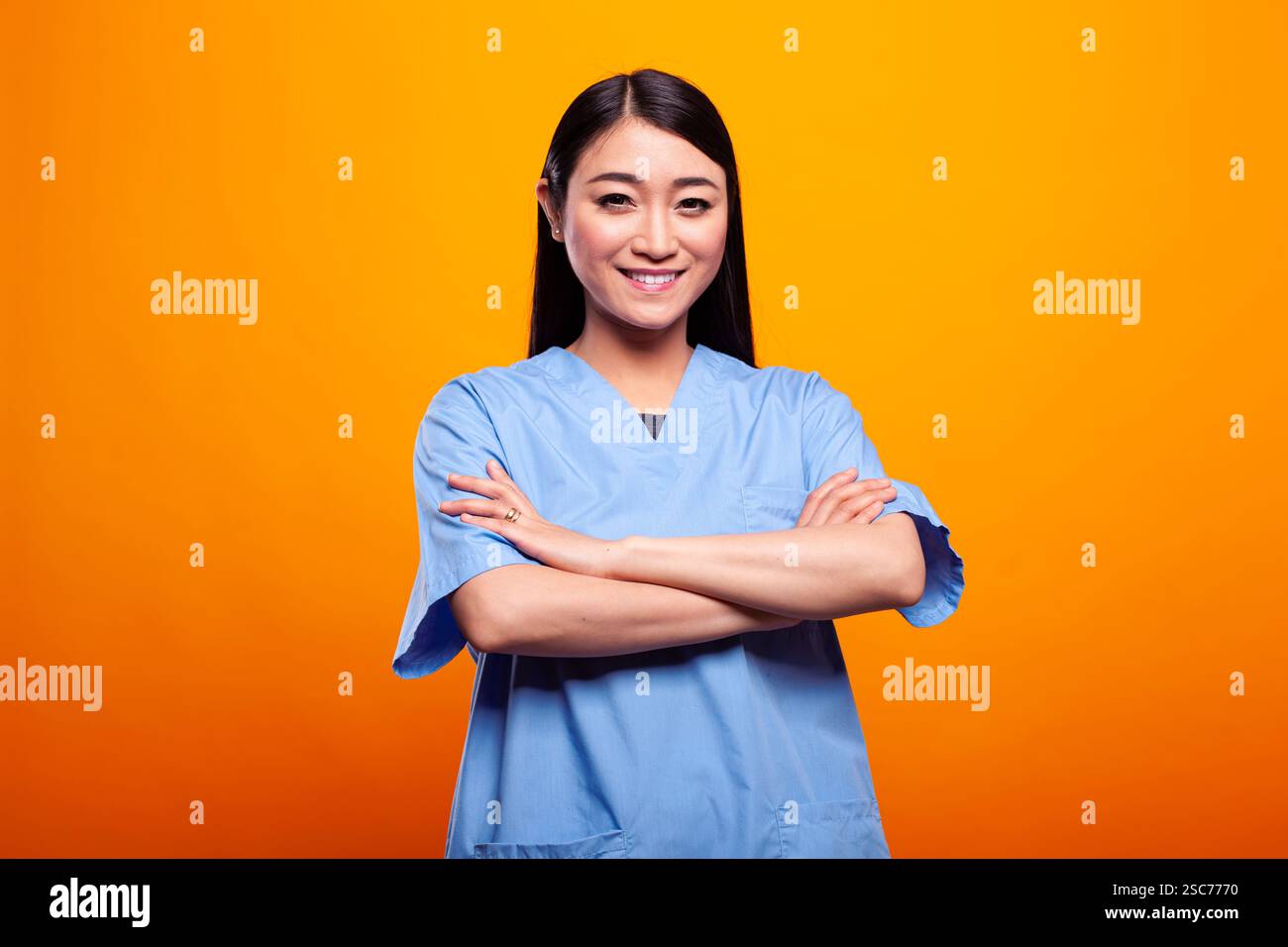 Cheerful young female doctor wearing blue scrubs is confidently posing ...