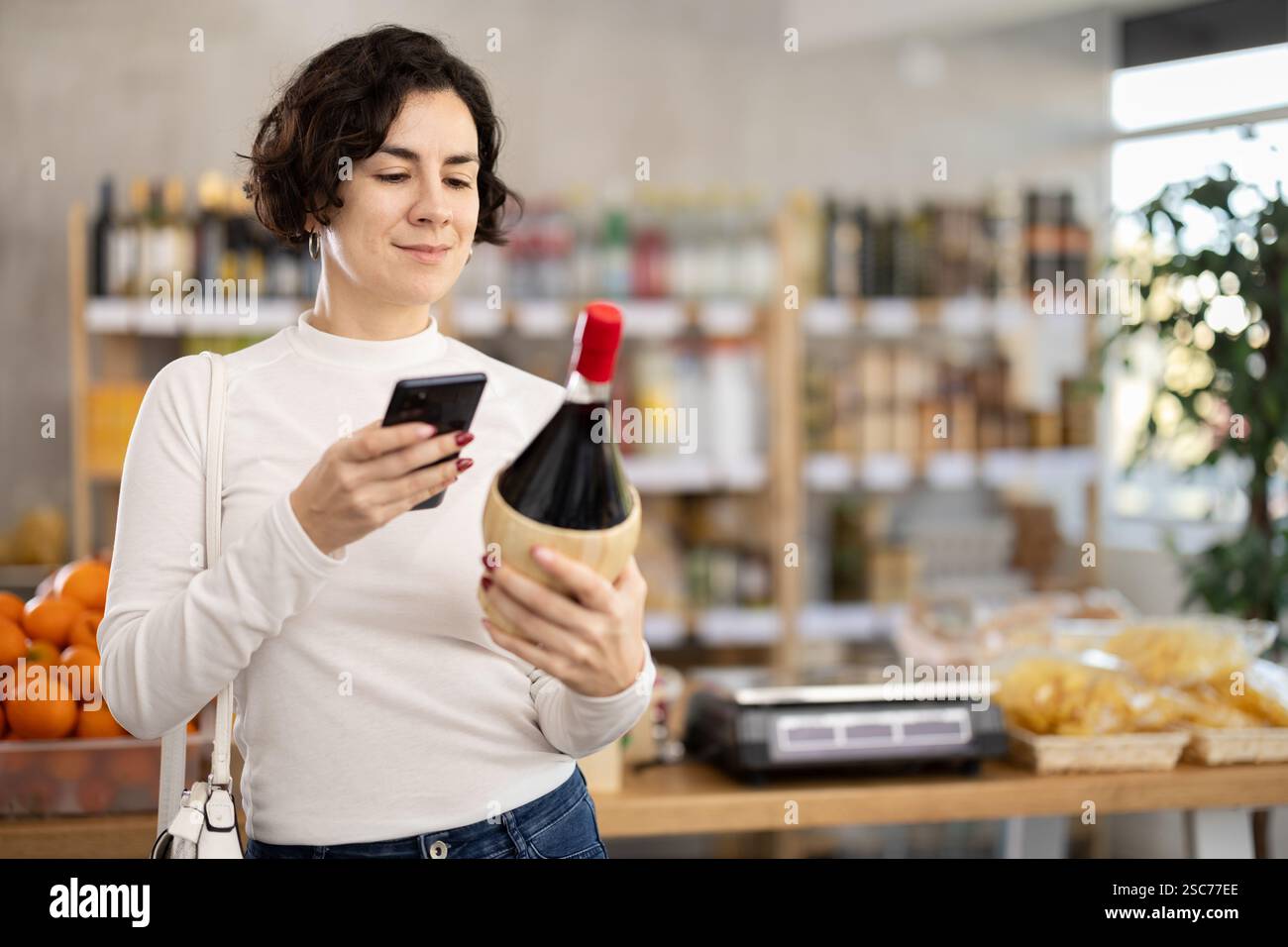 Adult woman scanning qr code of wine Stock Photo - Alamy