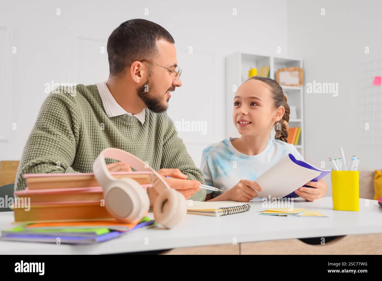 Teenage girl studying with tutor at home Stock Photo - Alamy