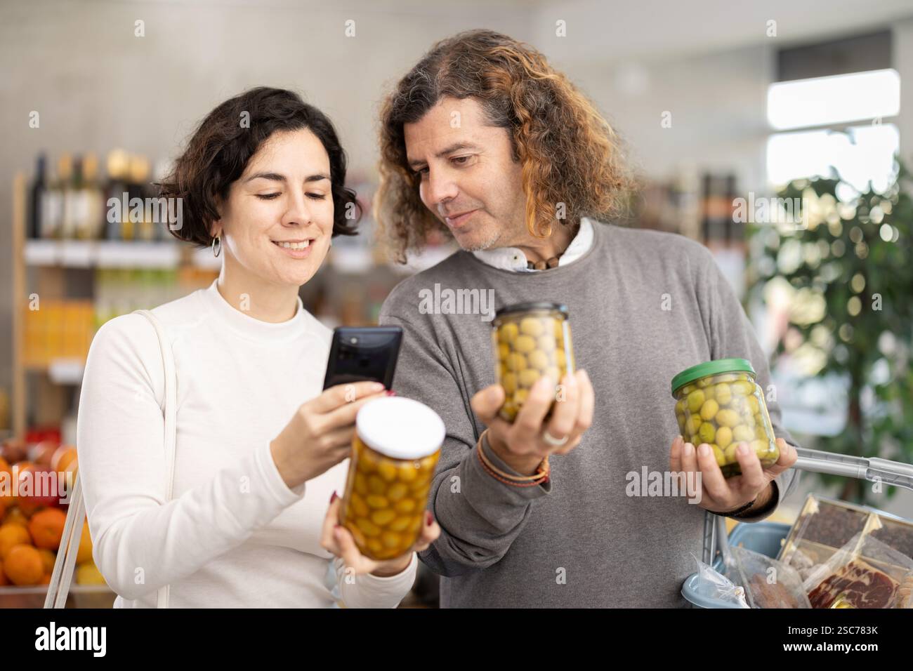 Checking expiration date of green olives - wife and husband shoppers ...