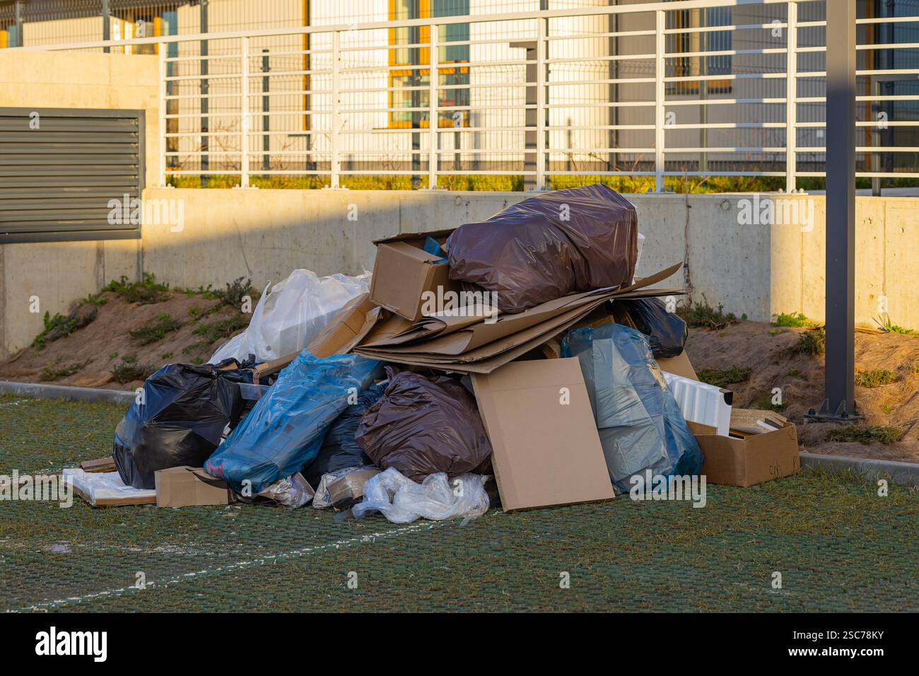 Pile of mixed garbage with black and blue plastic bags, cardboard boxes ...