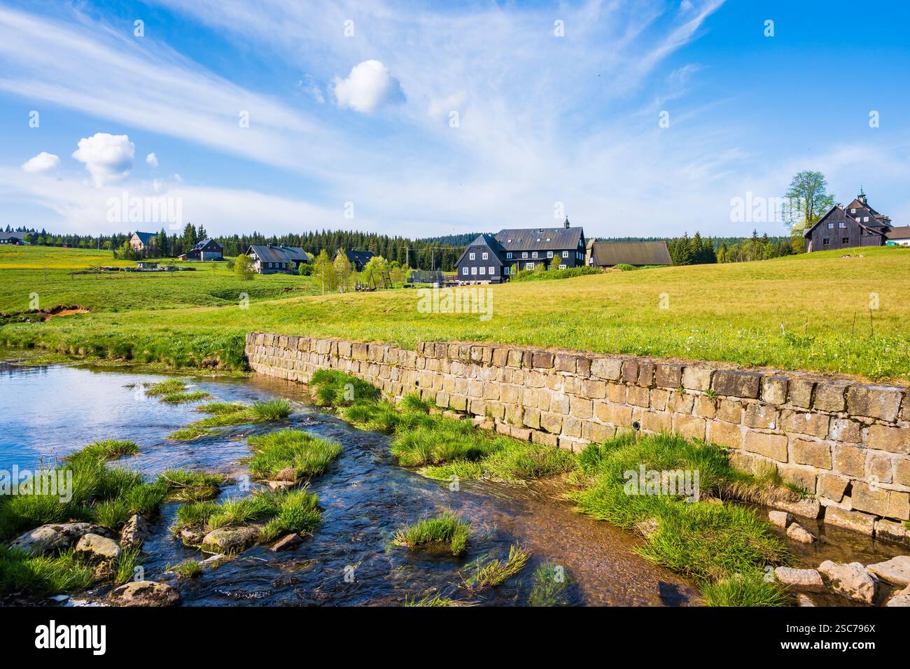Jizerka river and green meadows in Jizerka village on sunny spring day ...