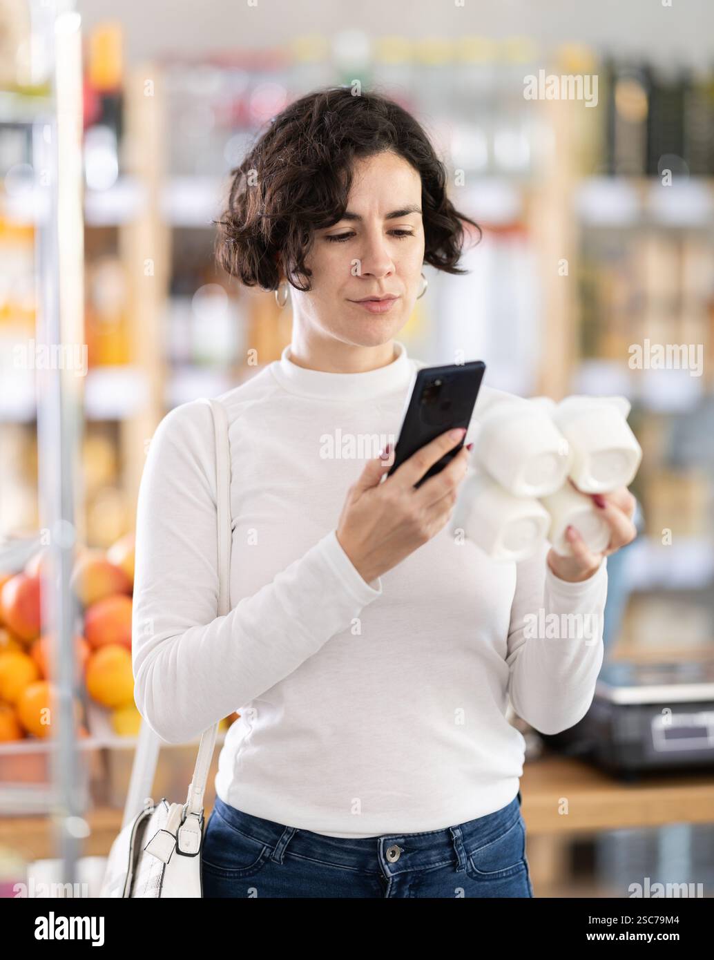 Woman get acquainted with food, scan QR code, take reading yogurt label ...