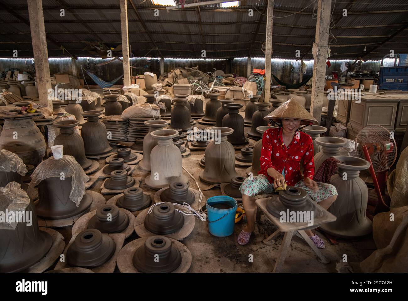 Woman wearing traditional Vietnamese conical hat making pottery in a ...