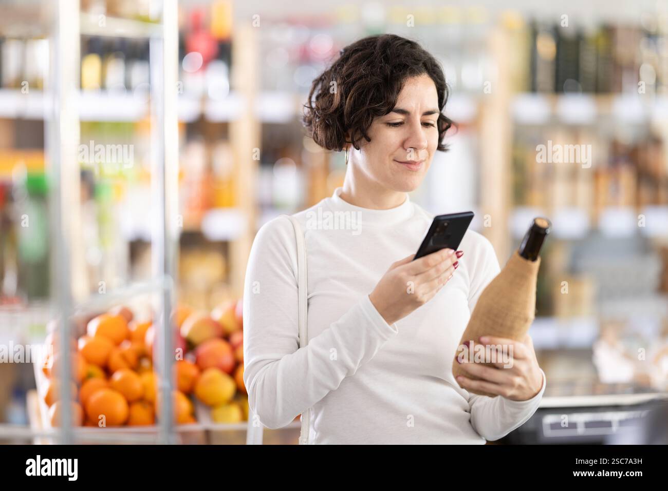 Adult woman scanning qr code of wine Stock Photo - Alamy