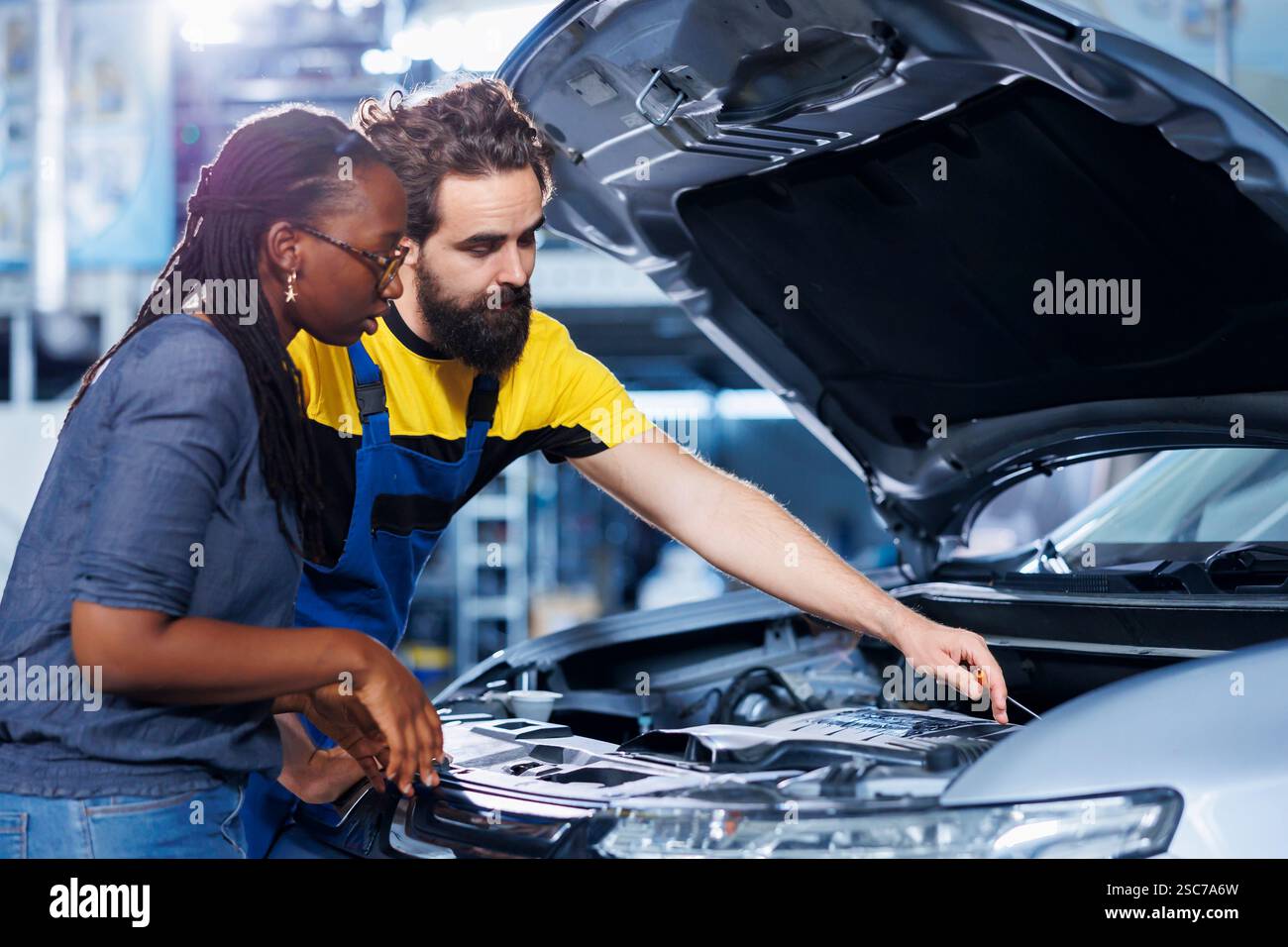Mechanic at auto repair shop conducts annual vehicle checkup, informing ...