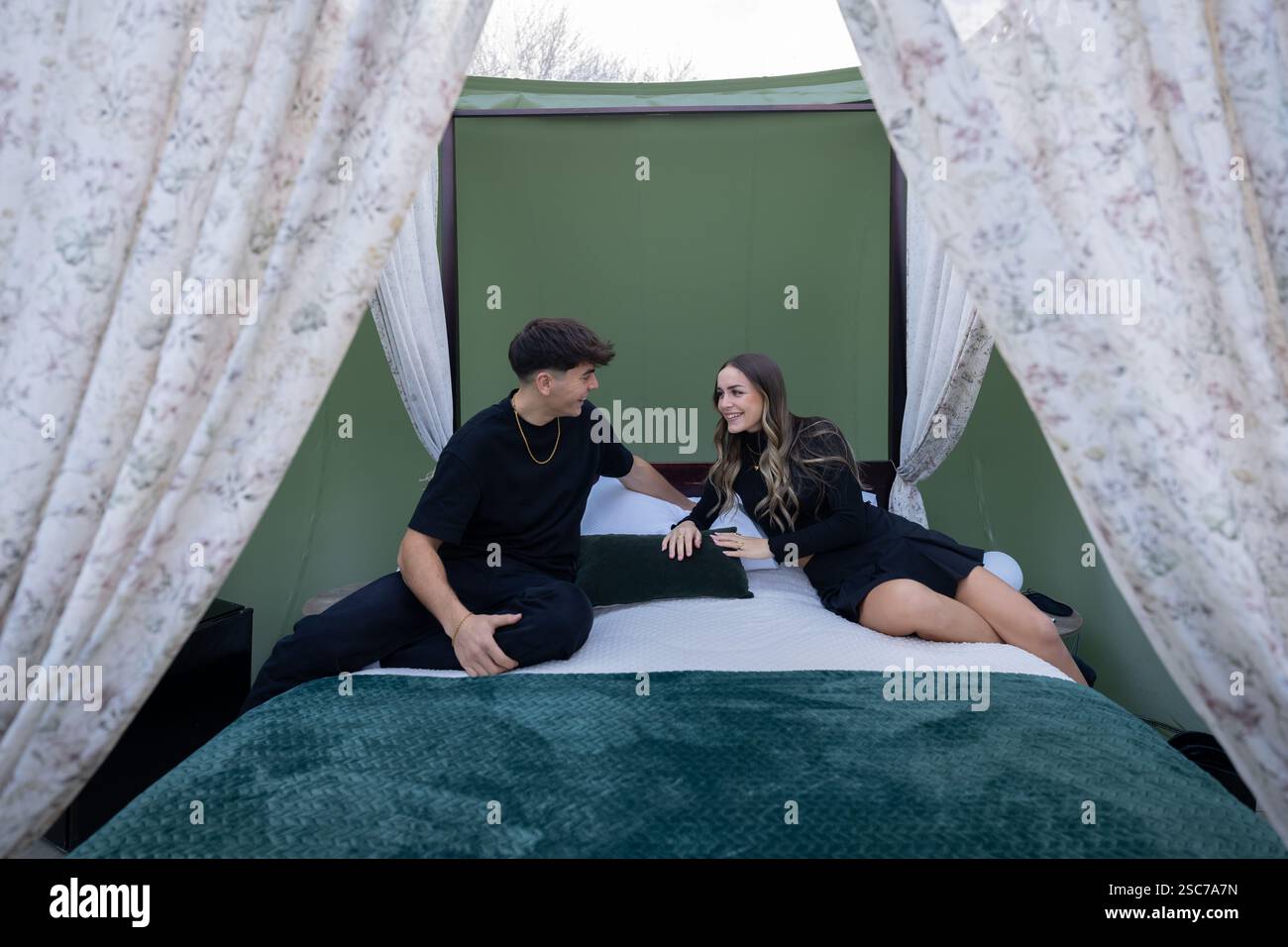 Happy young couple enjoying a romantic getaway, sitting on a ...