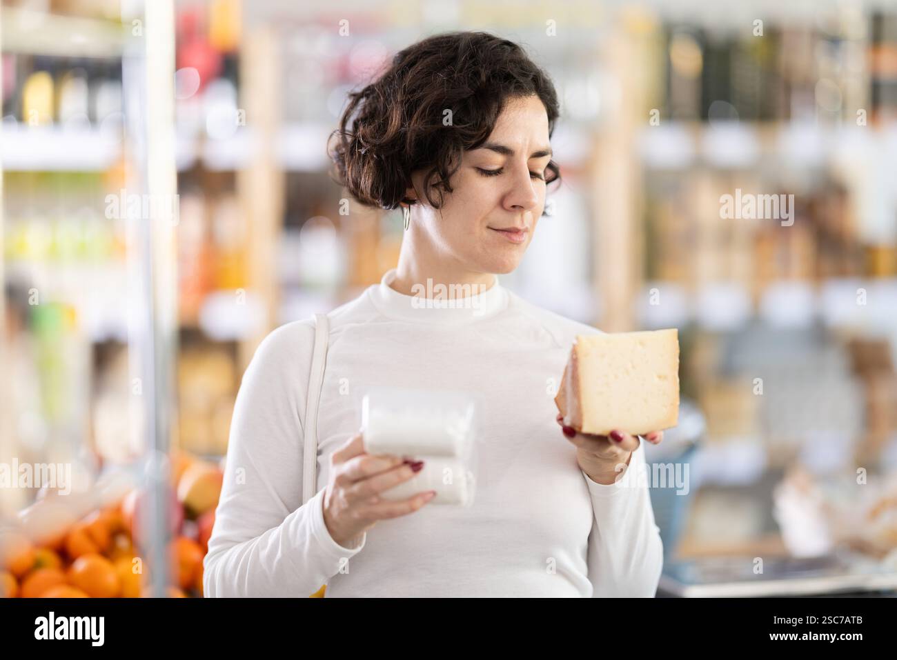 Adult woman choosing cheese in grocery store Stock Photo - Alamy