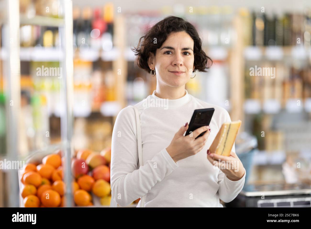 Adult woman scanning qr code for cheese Stock Photo - Alamy