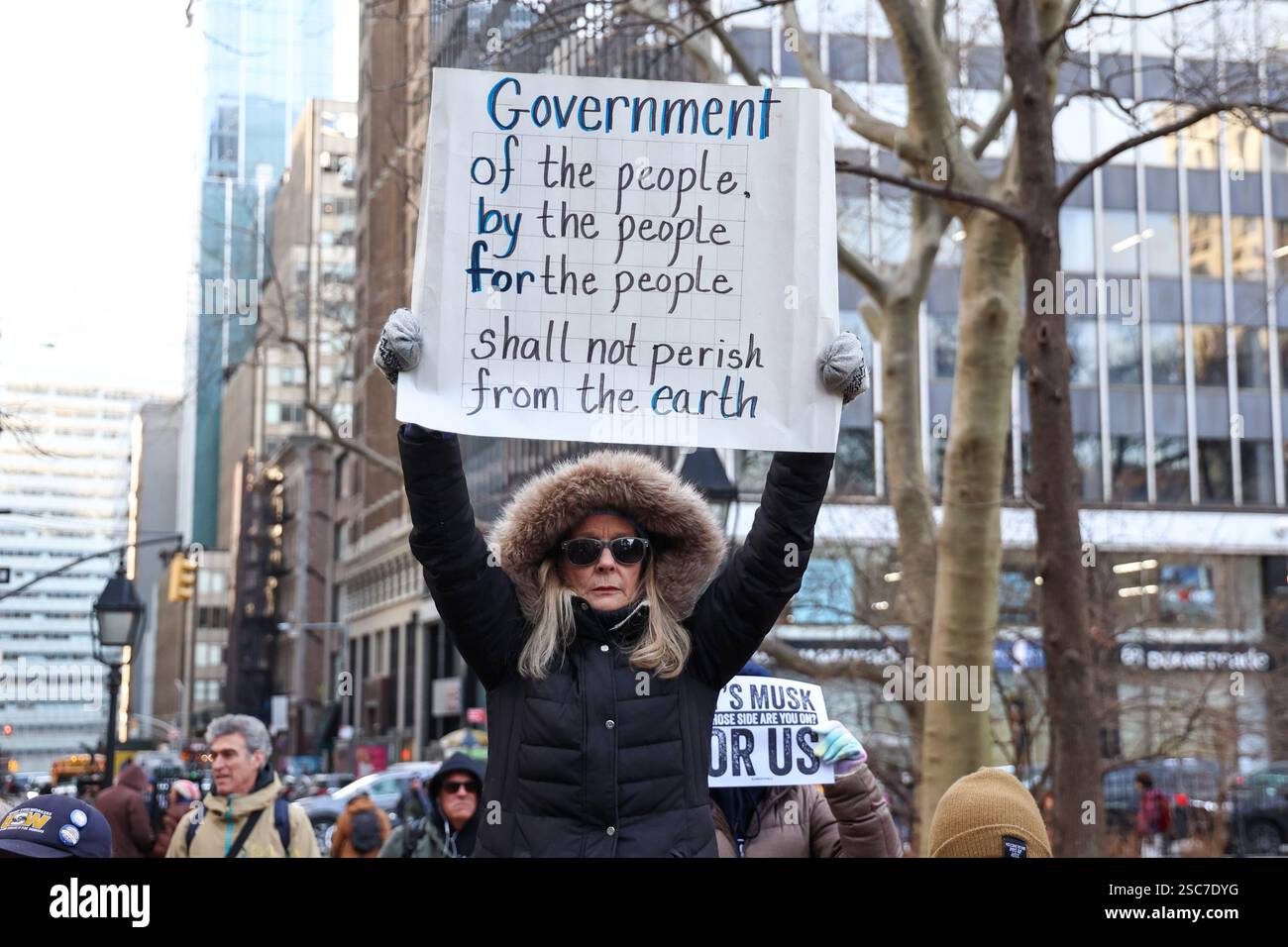 A protester holds up a sign addressing President Trump’s abuse of power ...