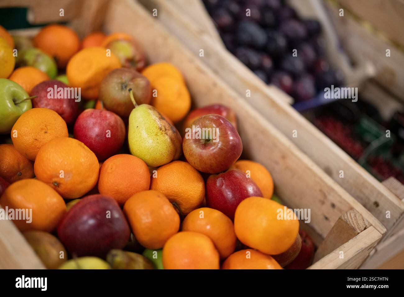 Fresh fruit (apples, oranges, pears) displayed in wooden crates at a ...