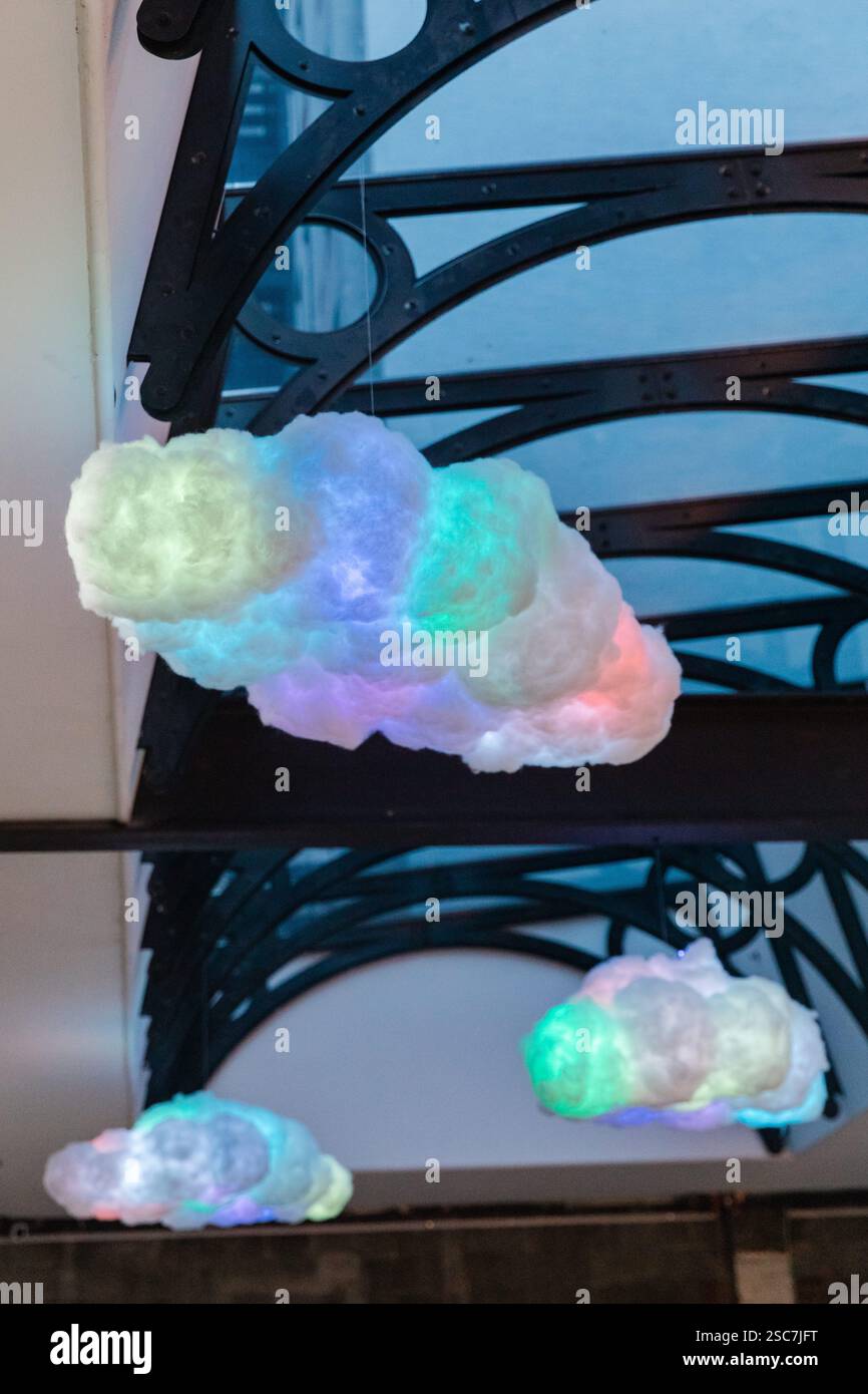 Softly glowing cloud-shaped light fixtures hang from a decorative ...