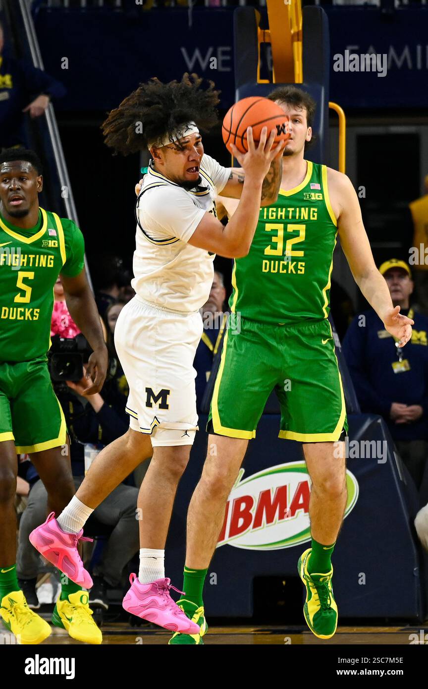 Michigan guard Tre Donaldson, front, grabs a rebound in front of Oregon ...