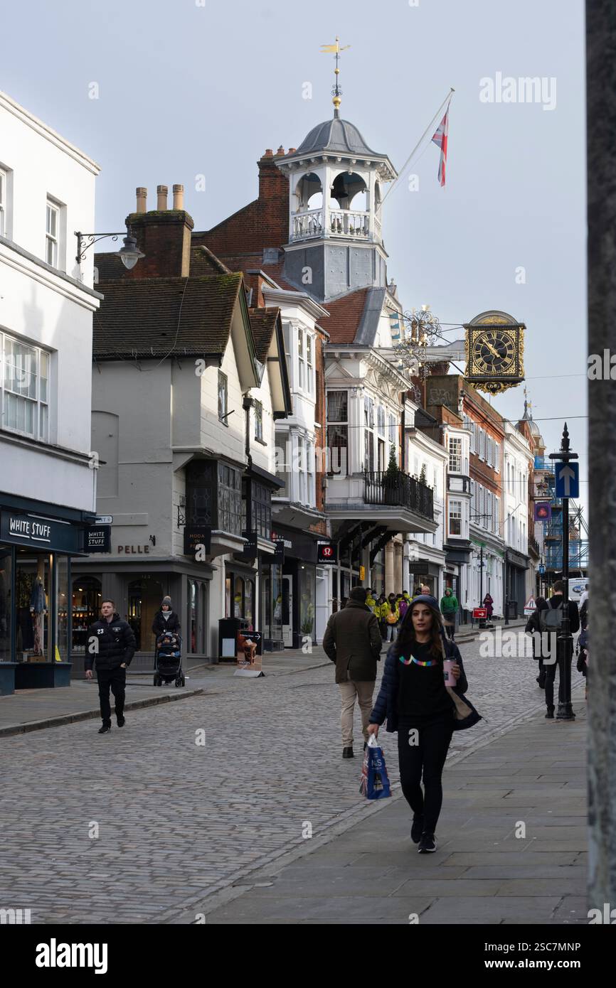 Pedestrians walk along High Street, Guildford UK. Historic buildings ...
