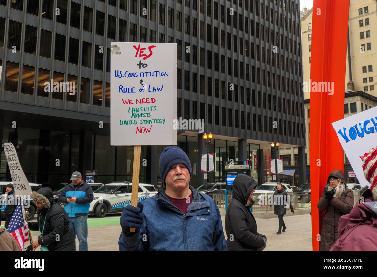 Man holding a protest sign at protest against Donald Trump and Elon ...
