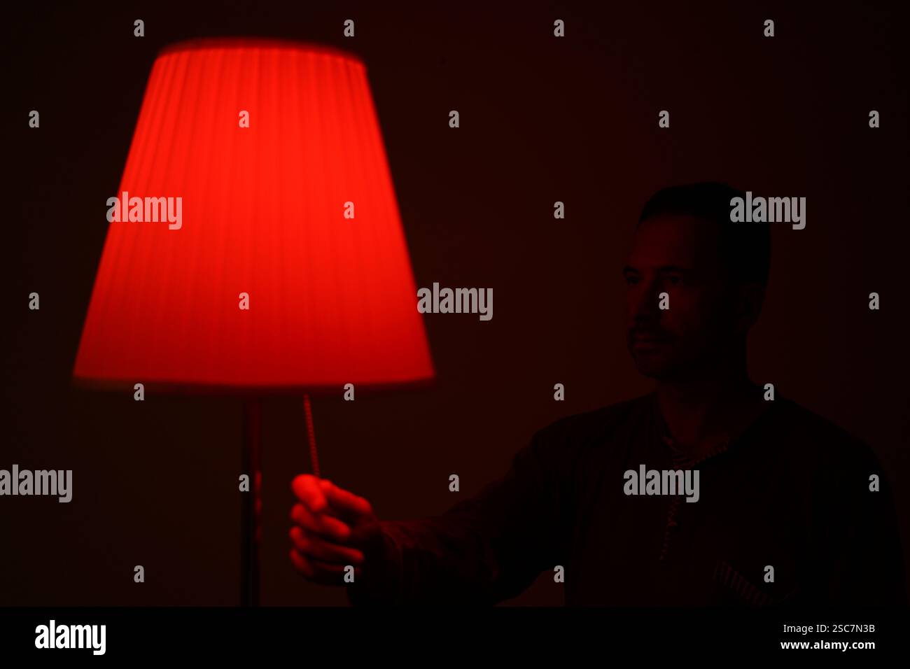 Lamp with strong red light on the left side under black background ...