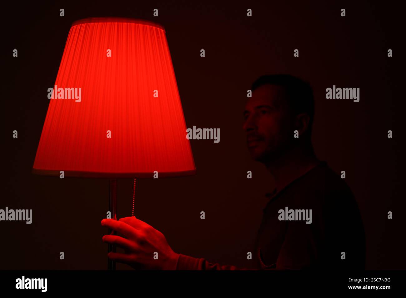 Lamp with strong red light on the left side under black background ...