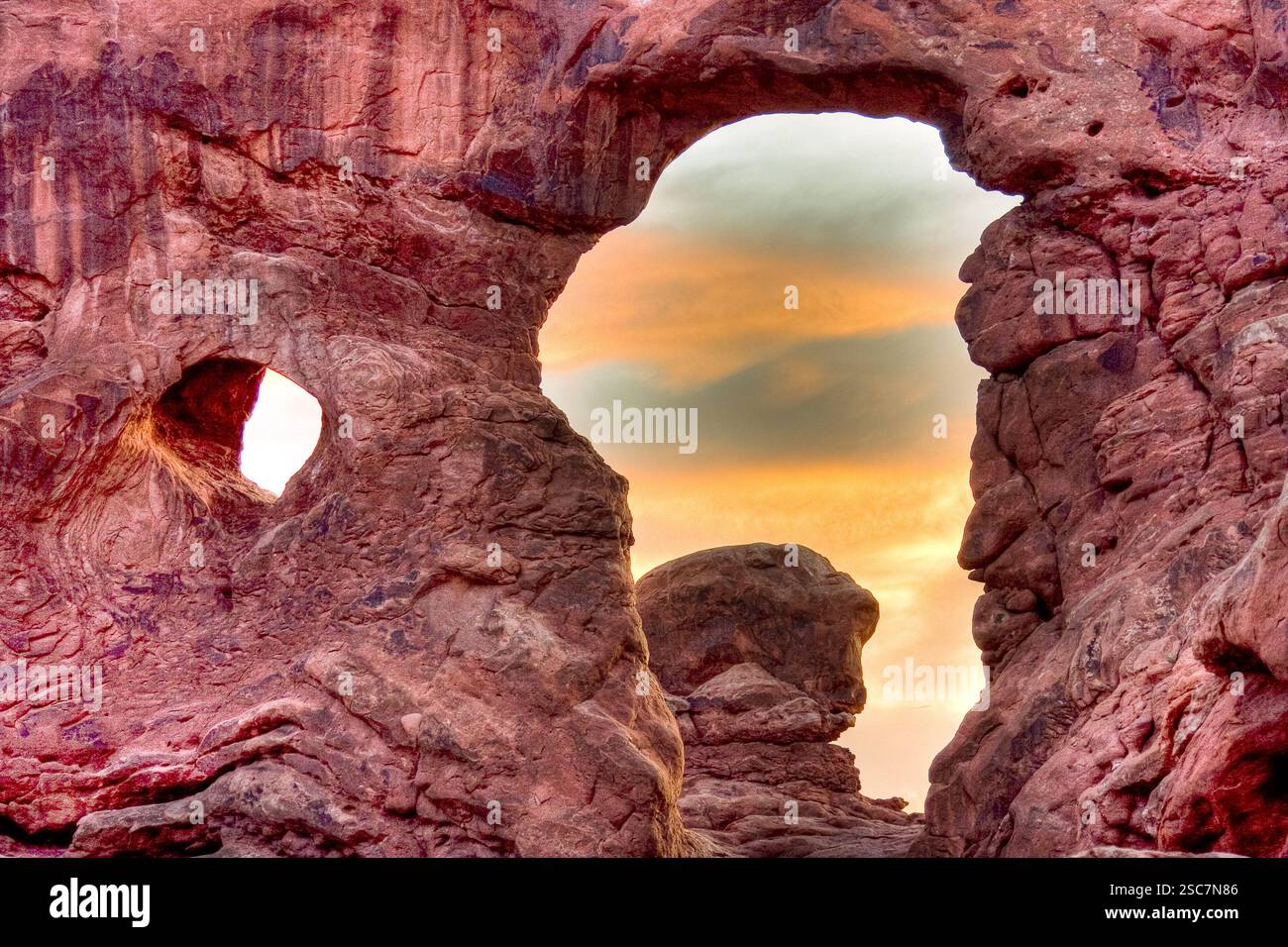 A large rock with a hole in it. The rock is red in color Stock Photo ...