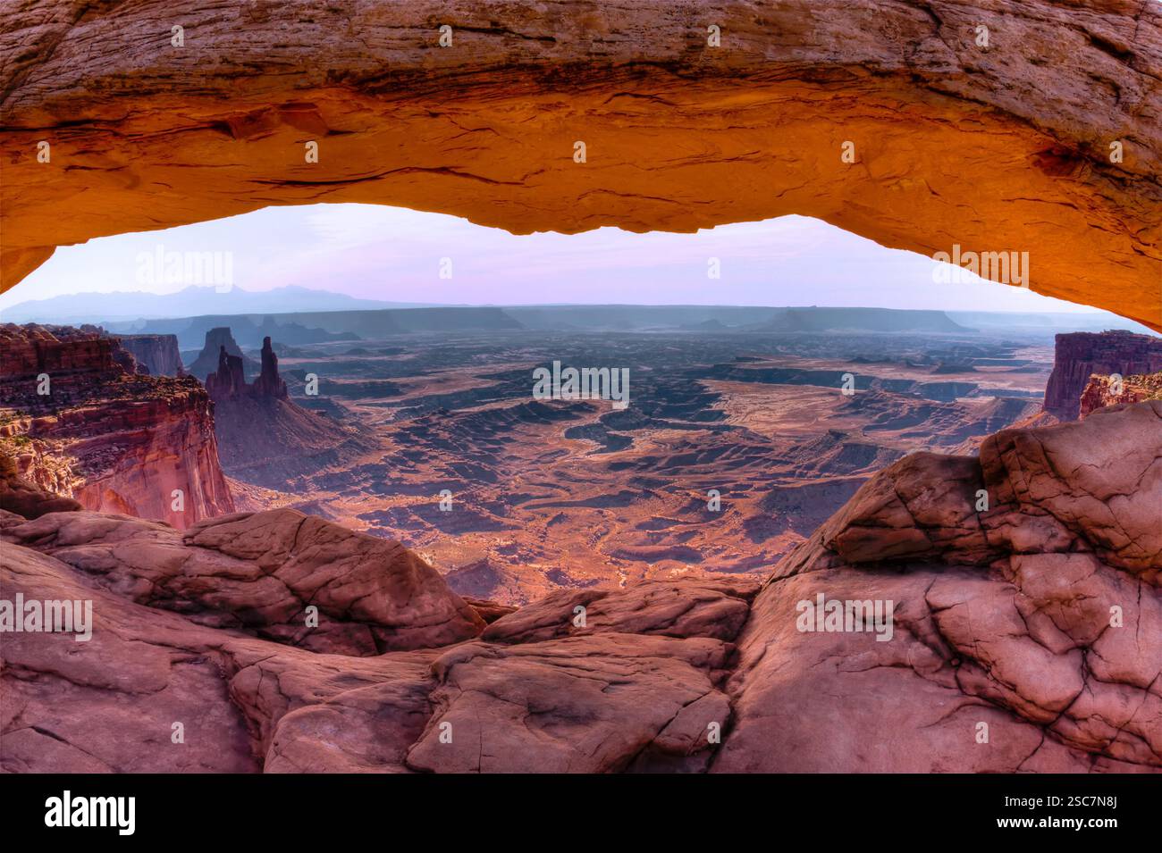 A stunning view of a desert landscape with a large rock archway in the ...