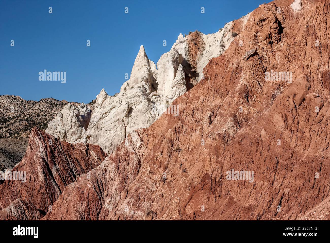 A mountain with a red and white rock face. The red rock is covered in ...