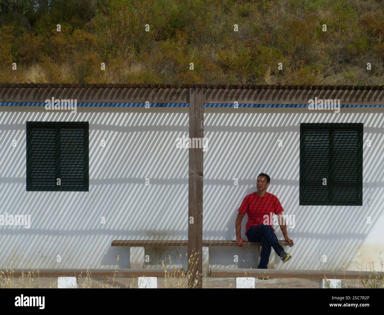 White European man sitting, behind him shadow drawings derived from the ...
