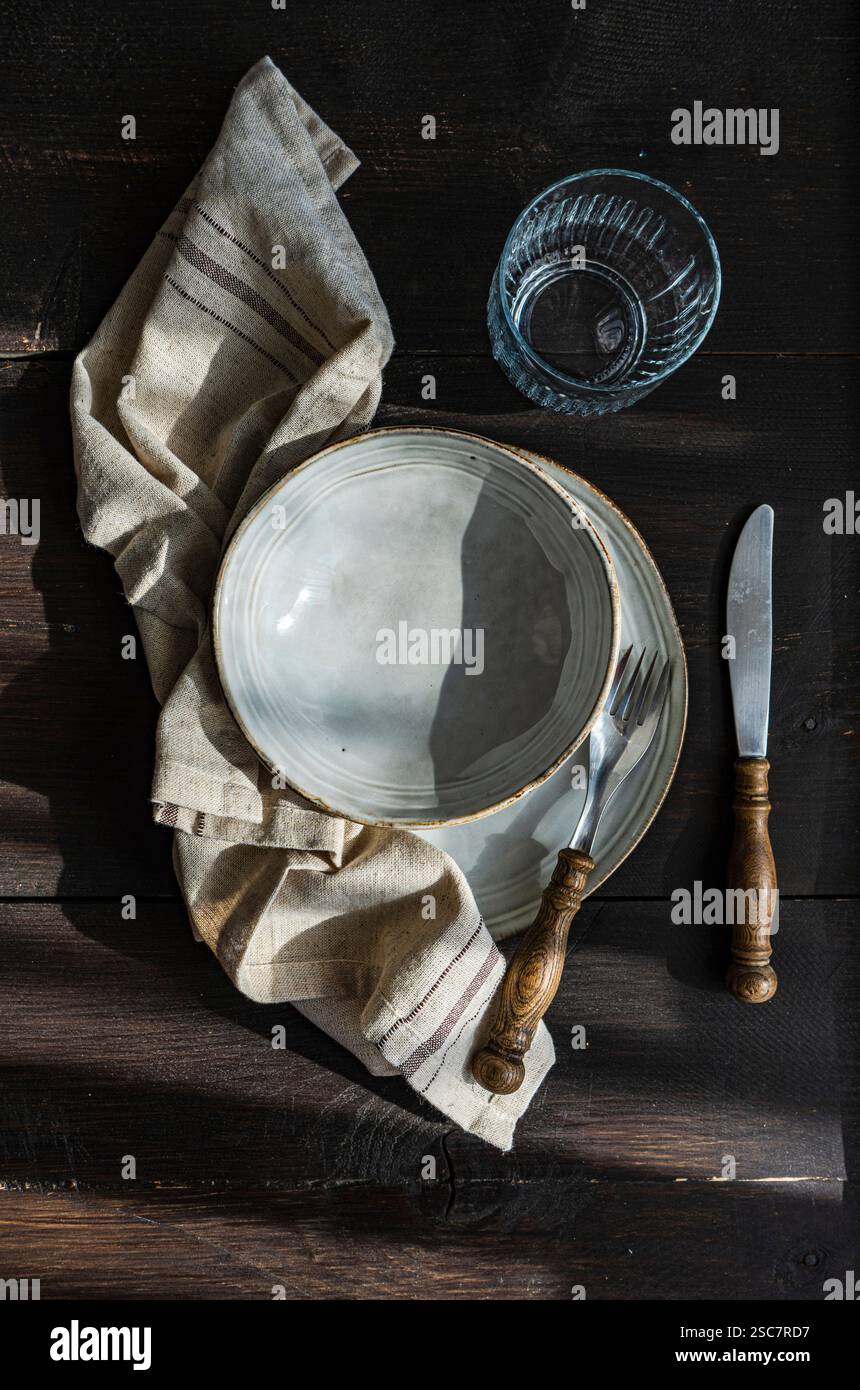Rustic place setting with bowl and cutlery Stock Photo - Alamy