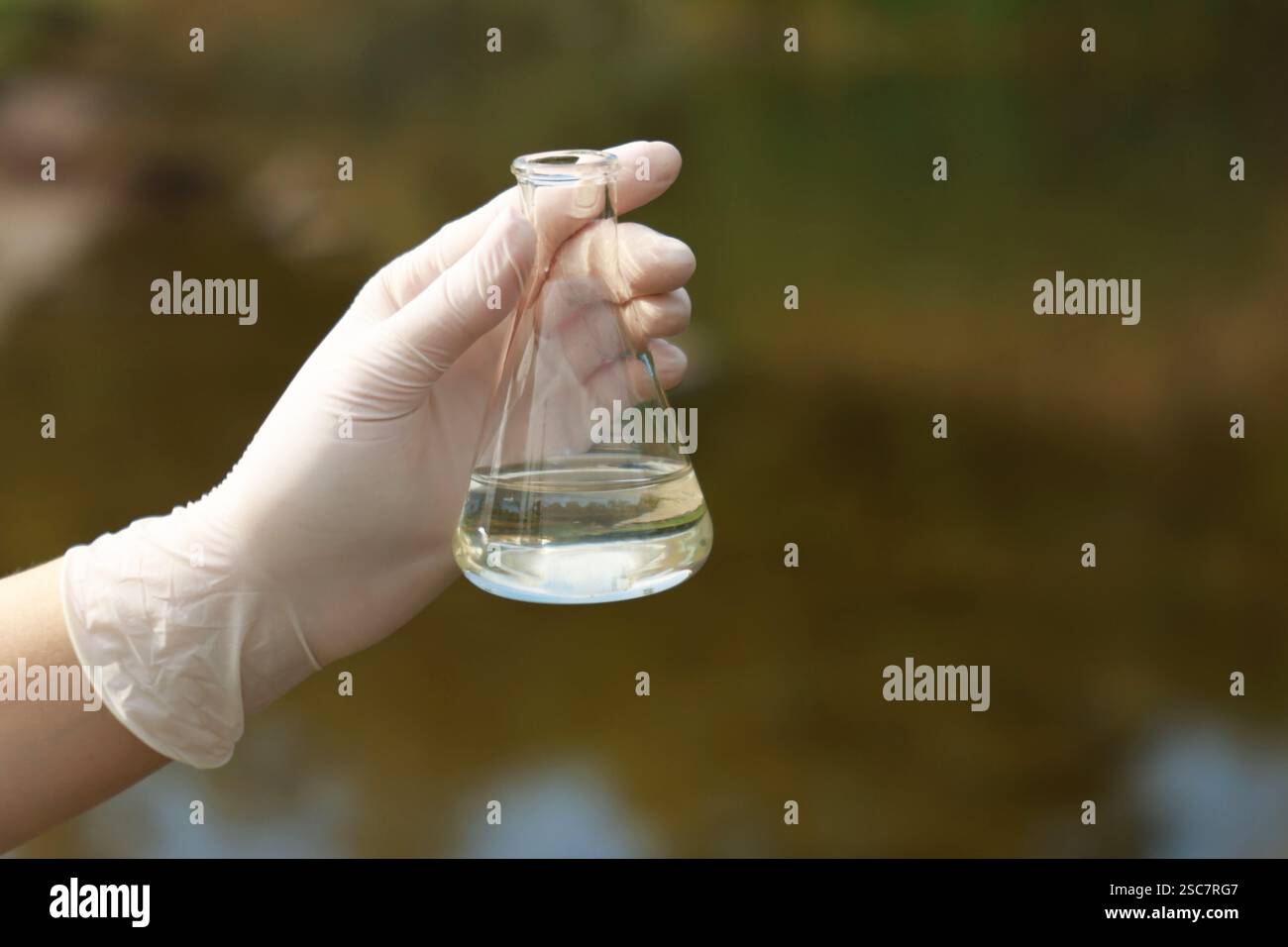 Examination of water quality. Researcher holding flask with sample ...