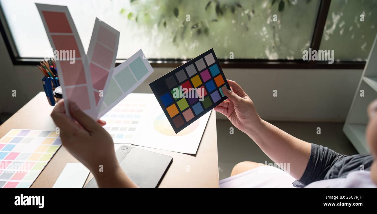 Graphic designer analyzing color palettes and samples at a creative ...