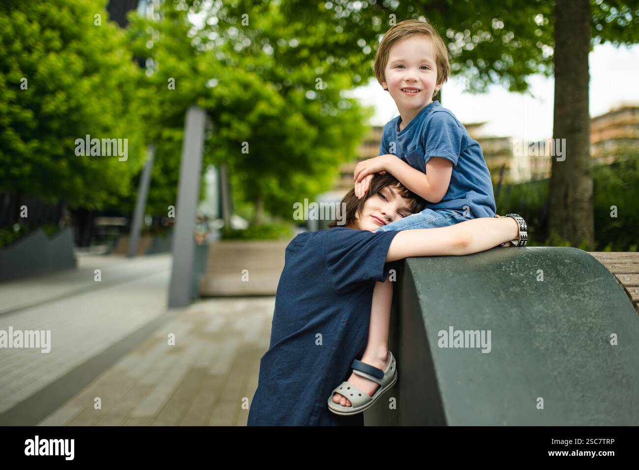 Cute big sister cuddling with her toddler brother. Adorable teenager ...