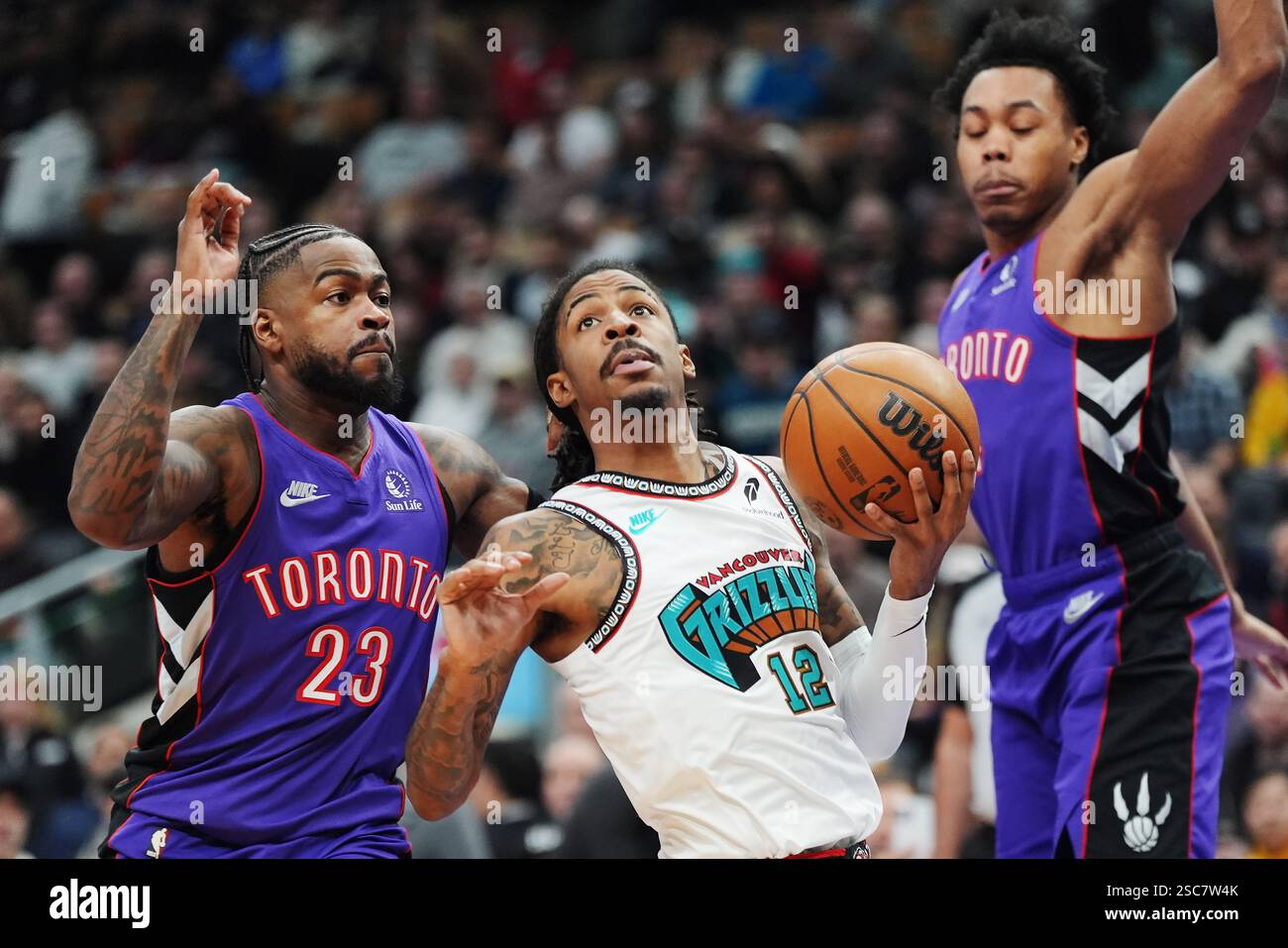 Memphis Grizzlies' Ja Morant (12) drives between Toronto Raptors' Jamal ...