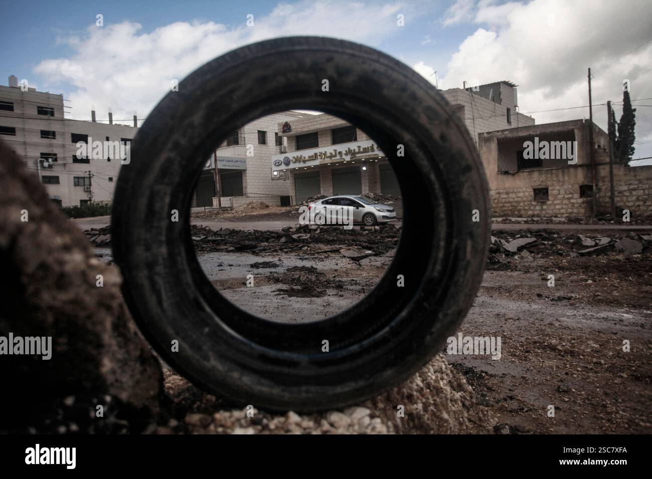 A Palestinian vehicle drives through a street destroyed by Israeli army ...