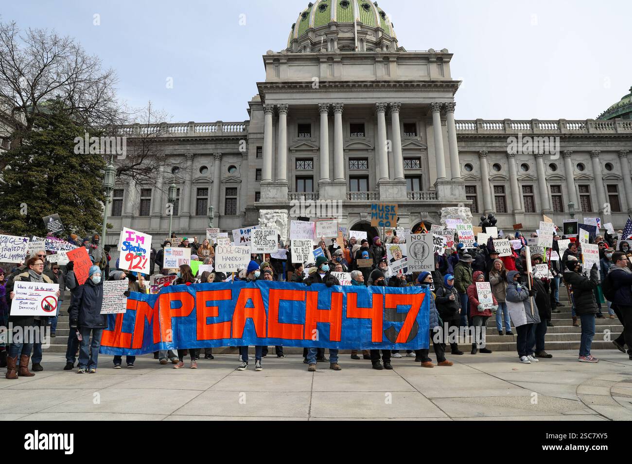 Protesters hold signs on the steps of the Pennsylvania Capitol during a ...