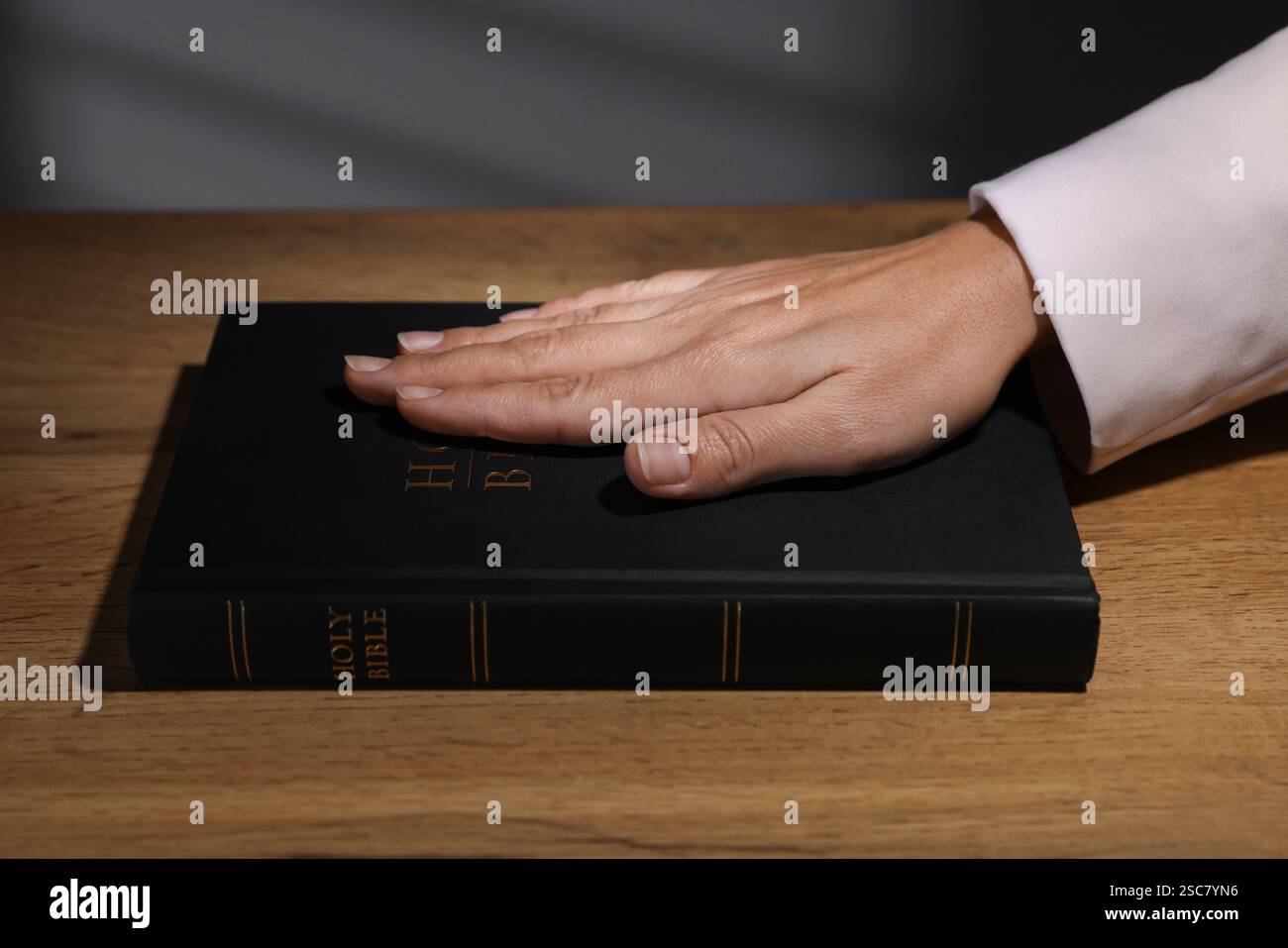 Woman taking oath with her hand on Bible at wooden table, closeup Stock ...