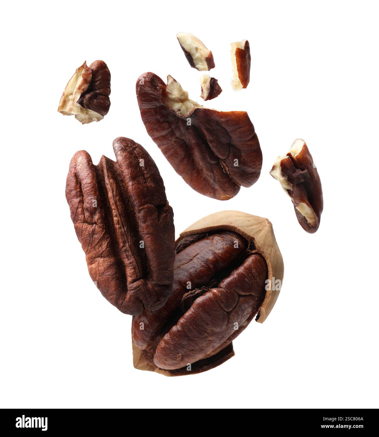 Broken pecan nuts in air on white background Stock Photo - Alamy