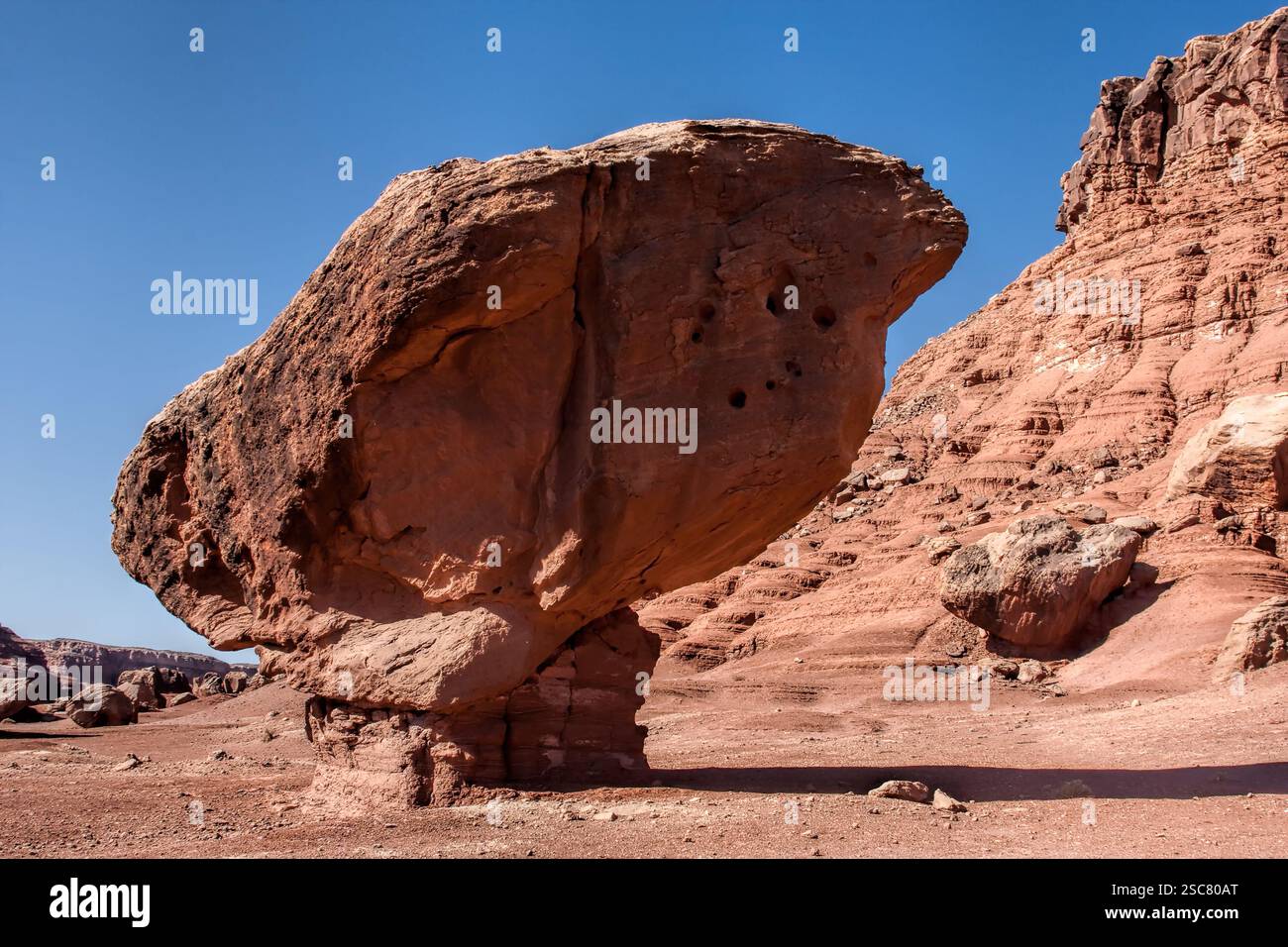 A large rock in the desert. The rock is brown and has a unique shape ...