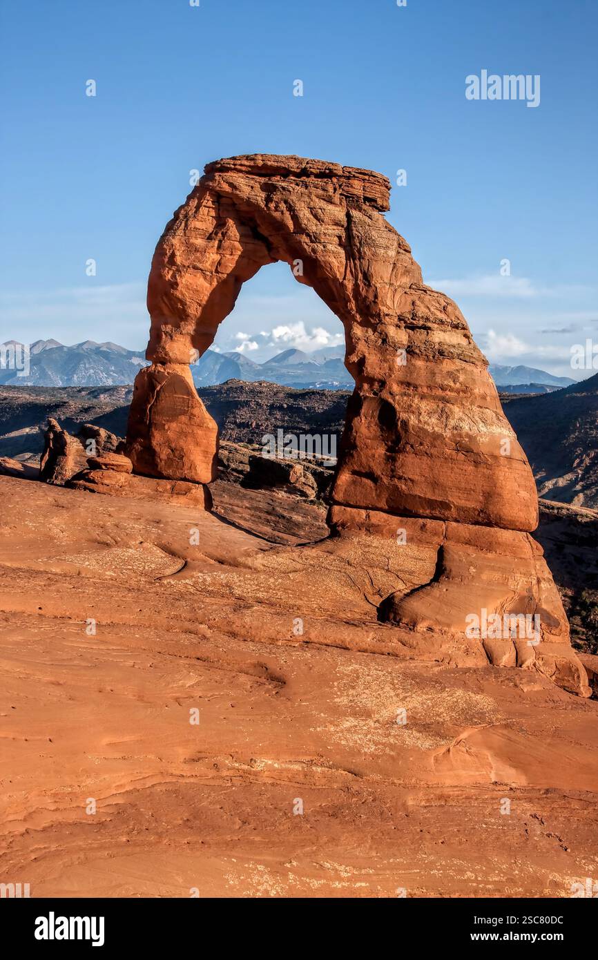 A large archway is in the middle of a desert. The archway is made of ...