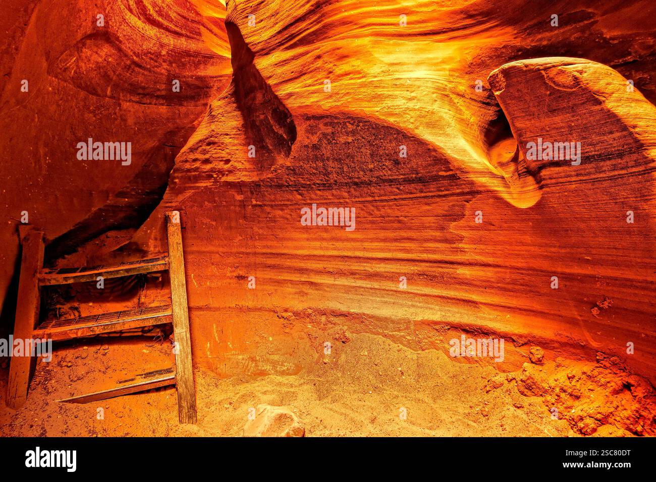 A ladder is in front of a cave. The ladder is wooden and has a metal ...