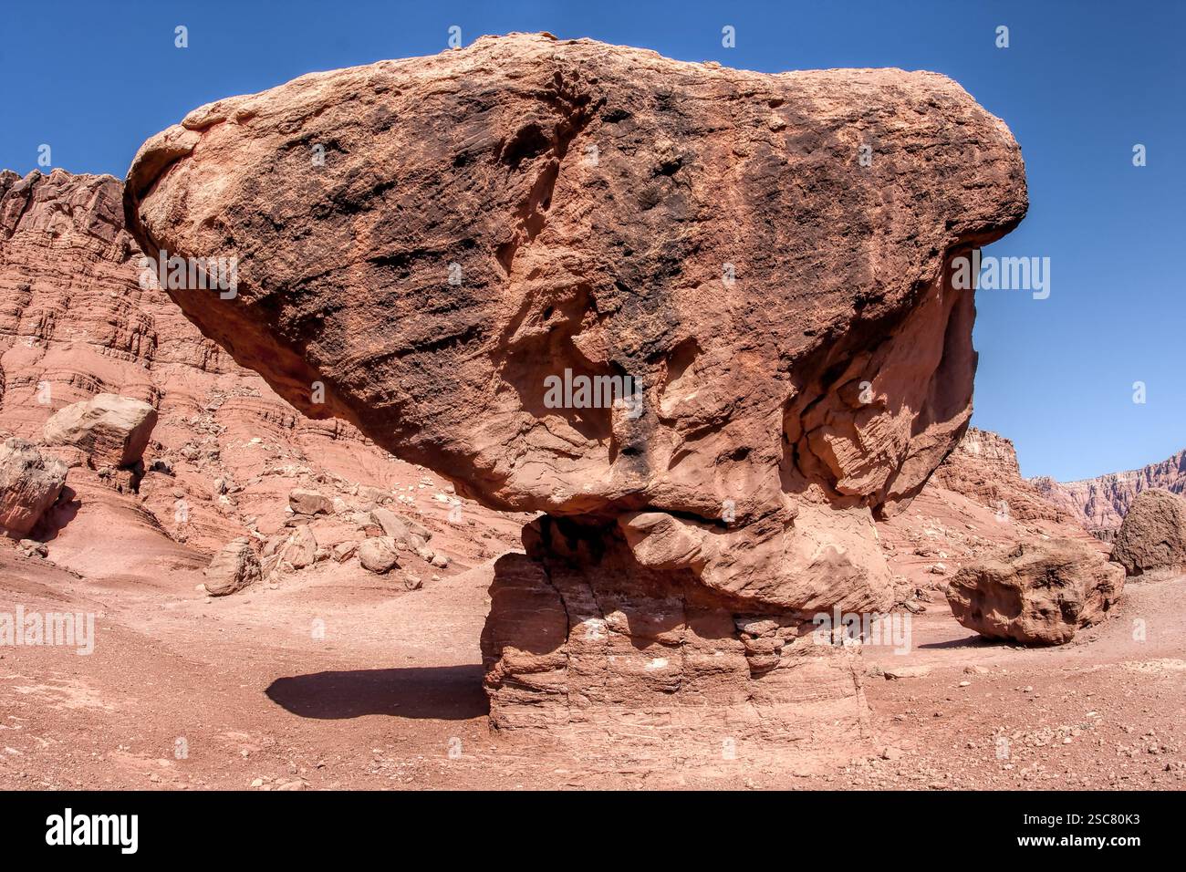 A large rock formation in the desert. The rock is shaped like a ...