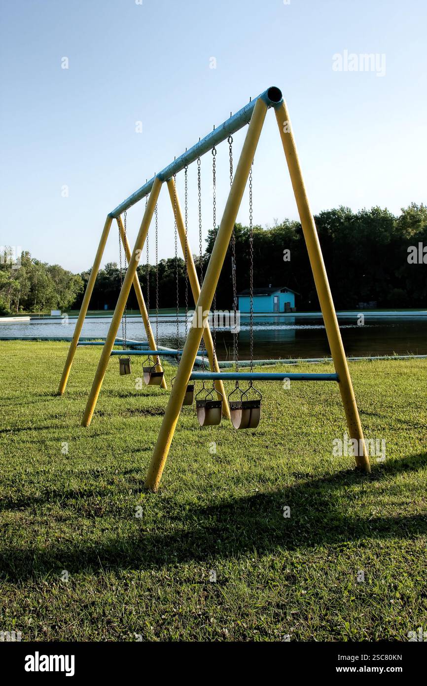 A yellow and blue swing set with two swings. The swings are empty. The ...