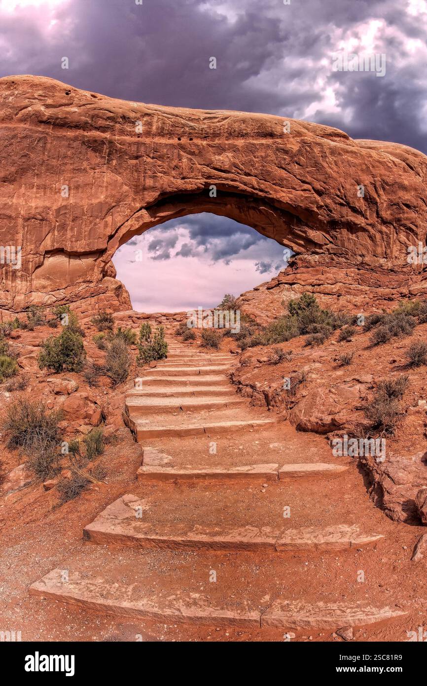A large archway in the desert. The archway is surrounded by a path of ...