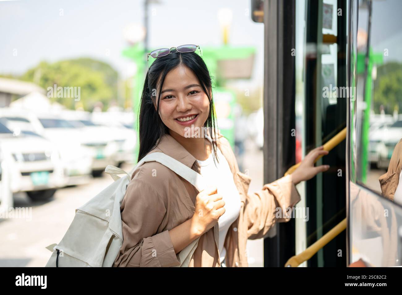 A beautiful, cheerful Asian woman in casual clothes with a backpack ...