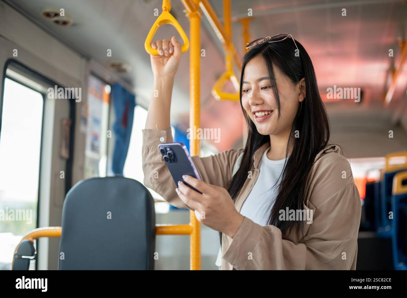 A cheerful, positive Asian woman in casual clothes enjoys chatting on ...