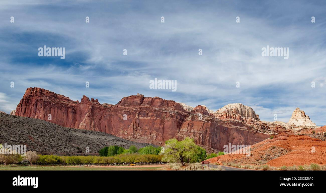 Massive cliffs of red Wingate sandstone, topped by white domes of ...