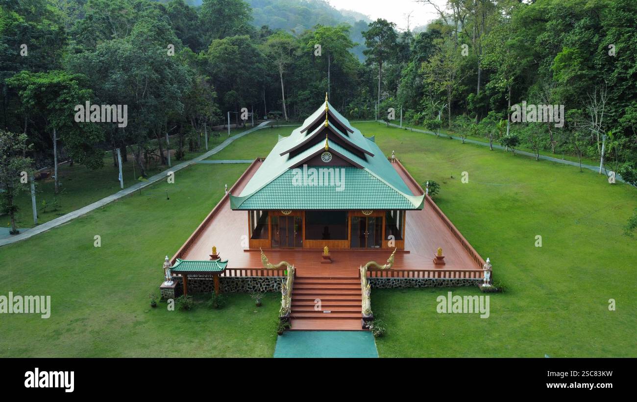 A peaceful monastery hidden in lush greenery, surrounded by rice fields ...