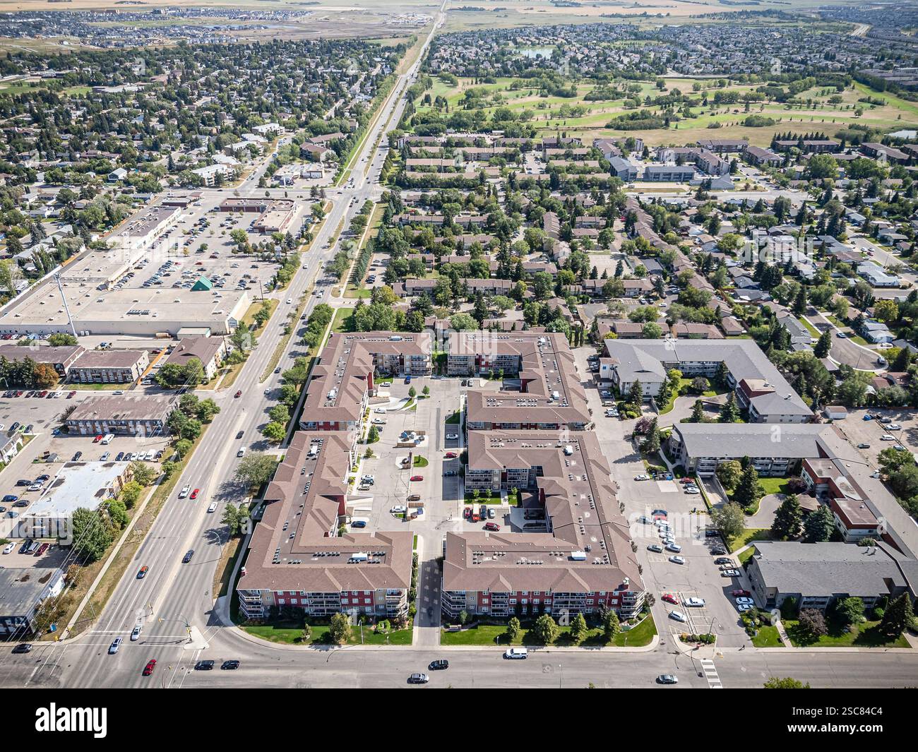 City street with a large apartment complex in the background. The ...