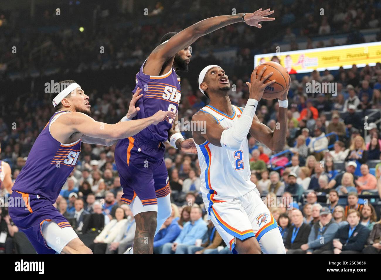 Oklahoma City Thunder guard Shai Gilgeous-Alexander, right, drives past Phoenix Suns forward ...