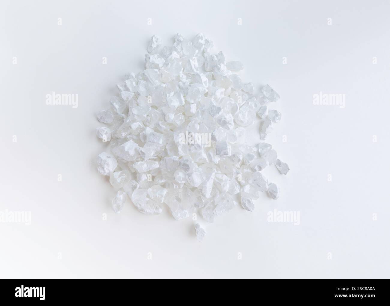 A pile of lemon salt crystals on a white background. Top view. Citric ...
