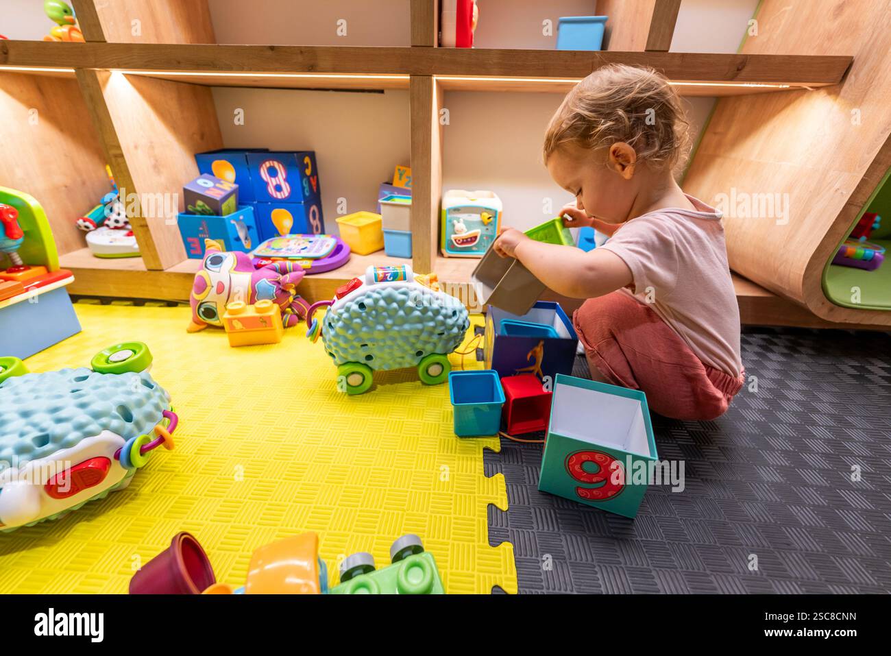 Child exploring toys and building blocks in a bright and interactive ...